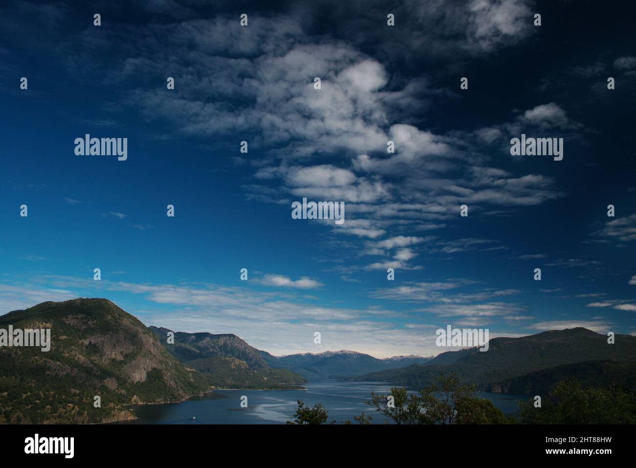 Mesmerizing view of lake and mountains under a cloudy sky Stock Photo ...