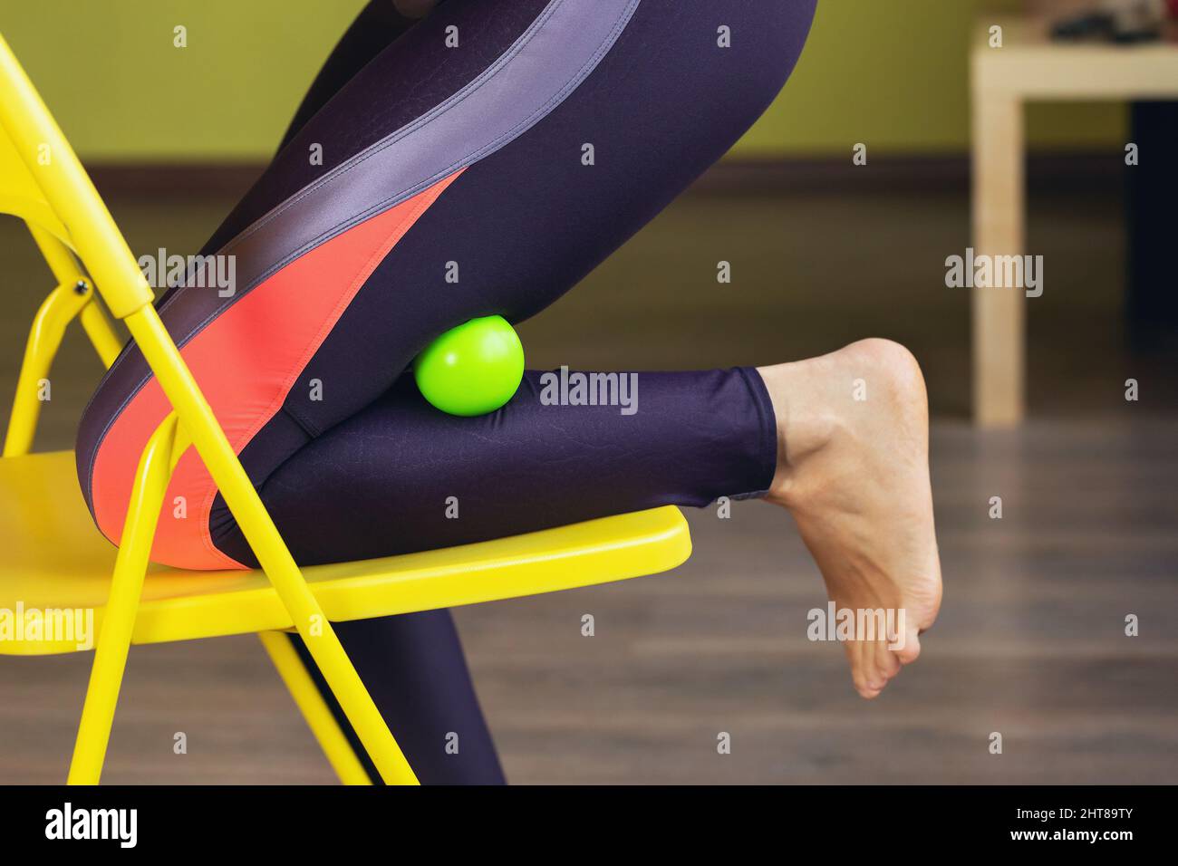 A woman in sportswear performs myofascial relaxation of the ...