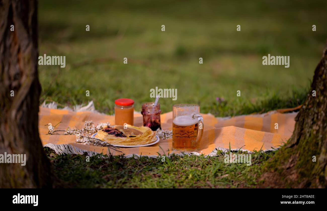 Closeup of beer cups during a picnic a plate of pancakes with jam on ...