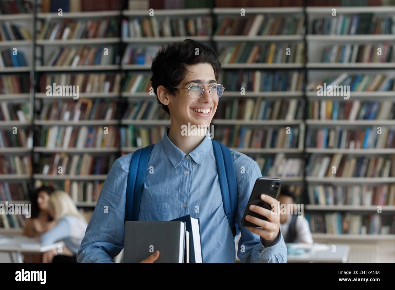 Happy dreamy young Jewish male student holding cellphone Stock Photo ...