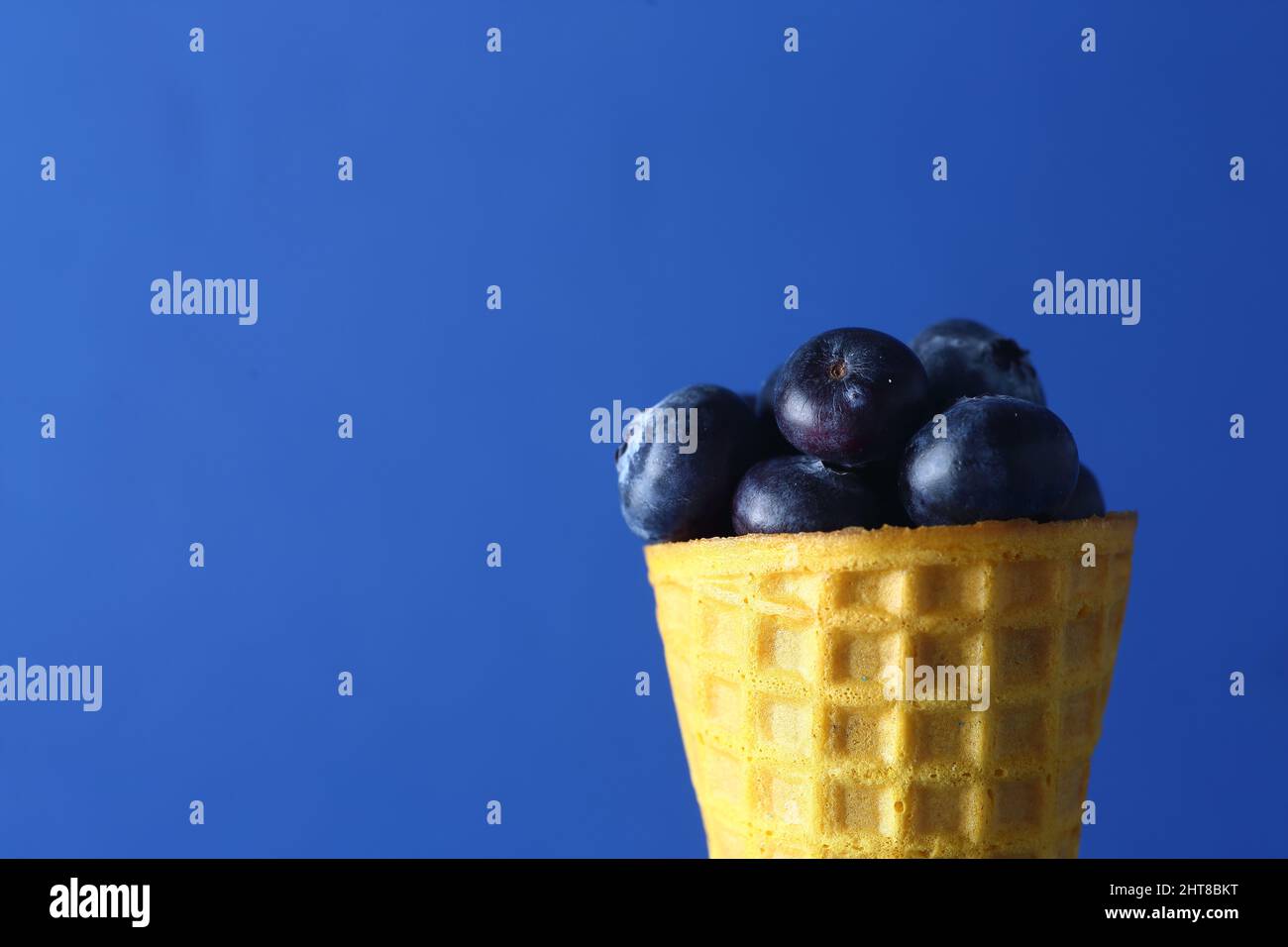 waffle cone of blueberry isolated against blue background Stock Photo ...