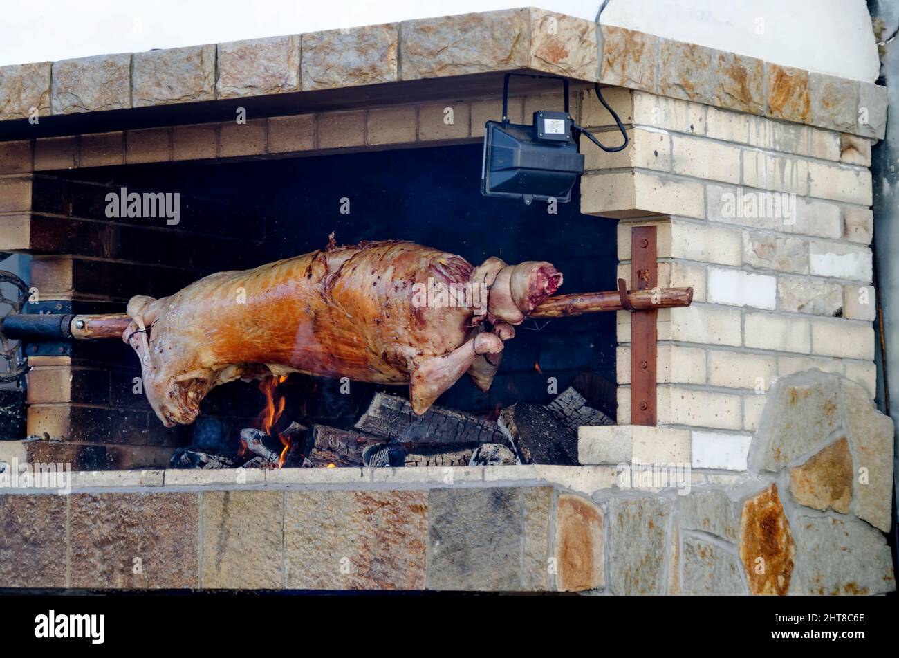 Lamb, roasted whole on a skewer over an open fire in an updated setting ...