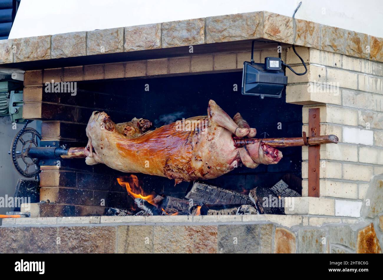 Lamb, roasted whole on a skewer over an open fire in an updated setting ...