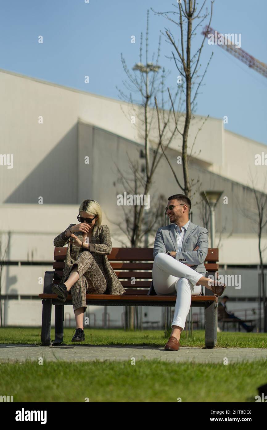 Urban business people are laughing while sitting on the bench Stock ...