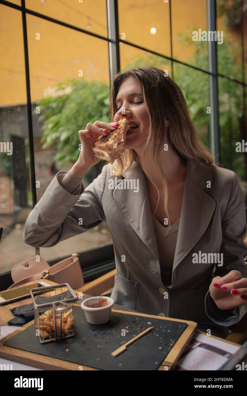 Attractive and amazing girl is eating her food in the resautrant while ...