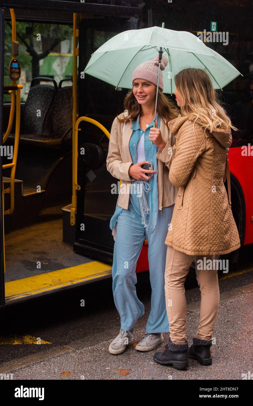 Attractive and beautiful girl friends are getting on the bus they were ...