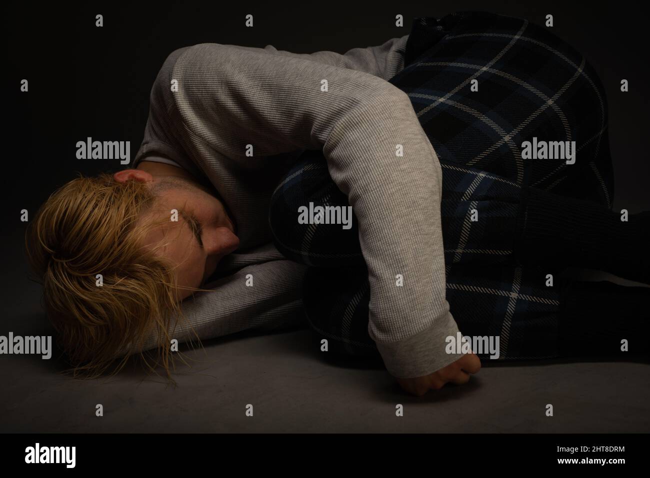 Depressed boy is laying on the ground while thinking about the pain ...