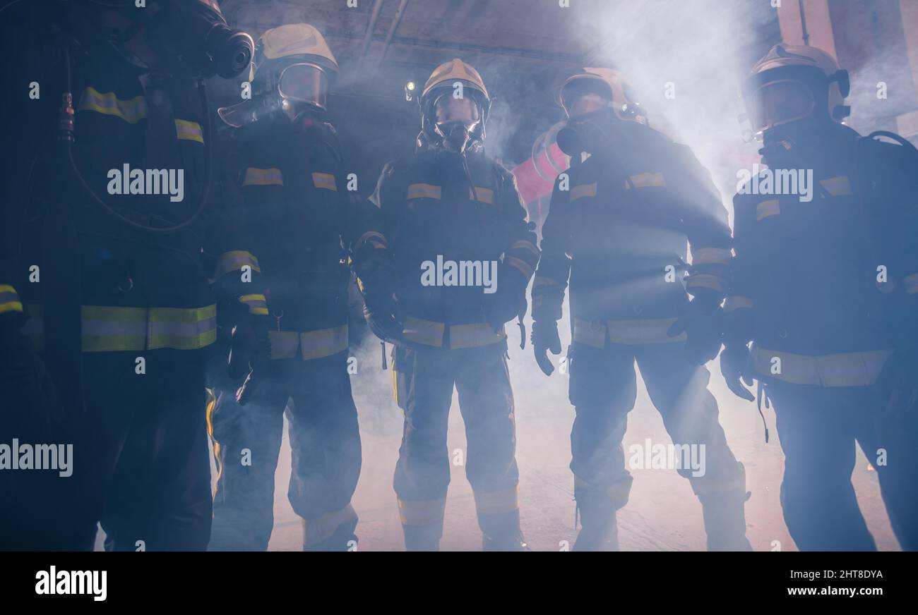 Portrait of group of firefighters in the middle of the smoke of the ...