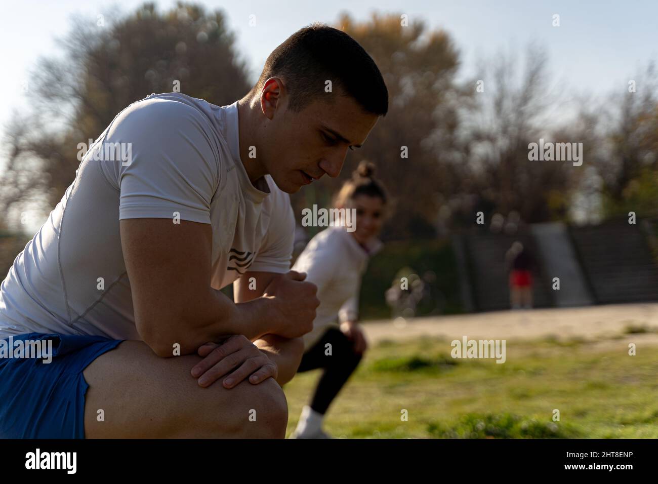 Two attractive and amazing fit friends are exercising and stretching ...