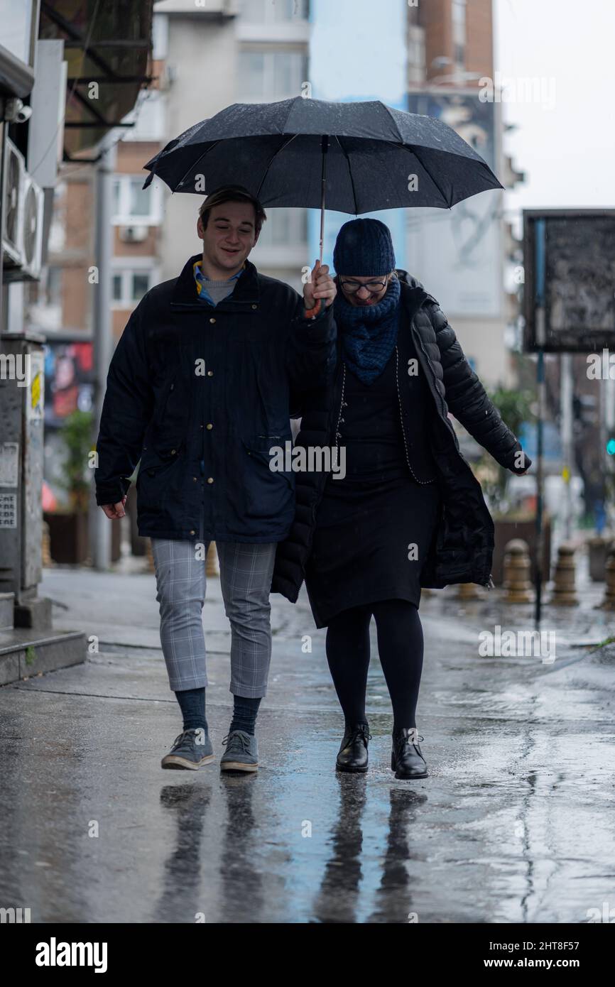 Two amazing business people are walking fast and smiling while talking ...