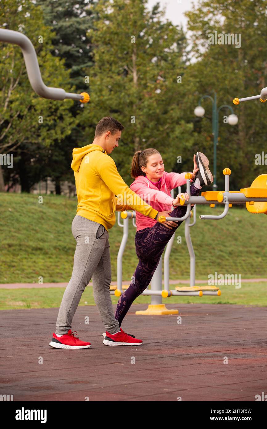 Attractive strong guy is helping and holding his girl so she can ...