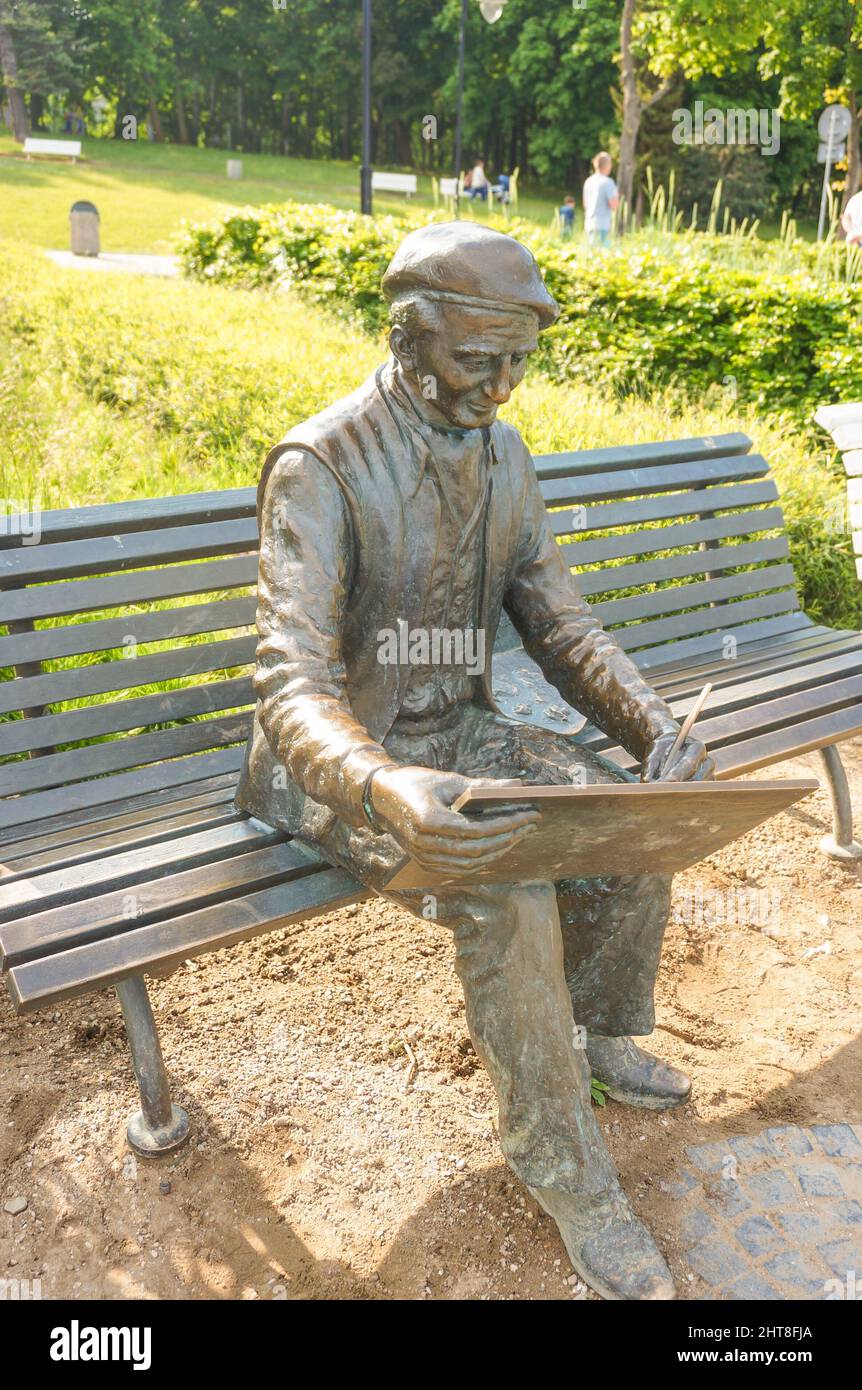 Closeup of a sculpture of a writing man sitting on a bench at the ...