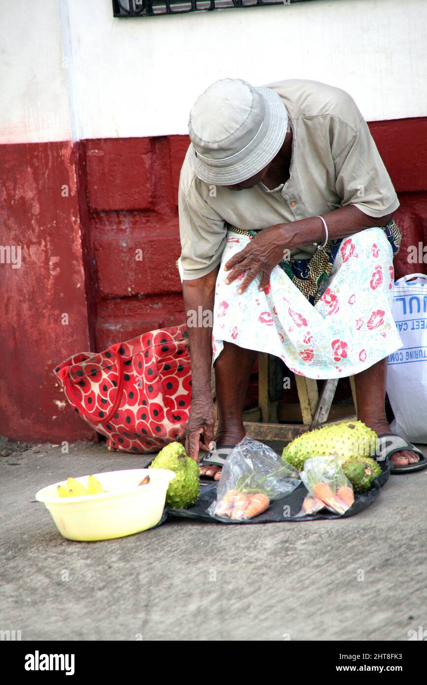 Caribbean female vendor selling her goods to tourist outside Stock ...