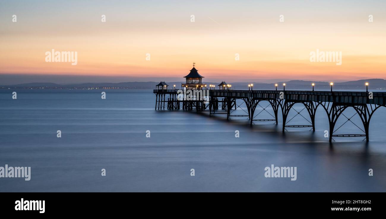 The sun sets over the Bristol Channel and South Wales at Clevedon Pier in Somerset, England ...