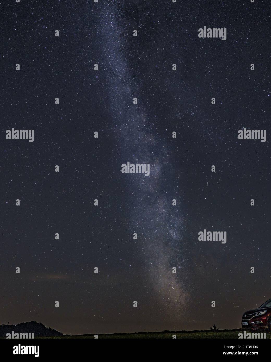 Vertical shot of the beautiful Milky Way in the night sky full of stars ...