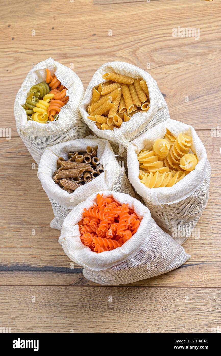 Top view of different types of macaroni in sacks on a wooden table ...
