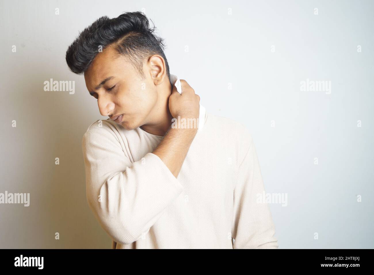 Young Indian man wiping sweat off his neck with a napkin Stock Photo ...