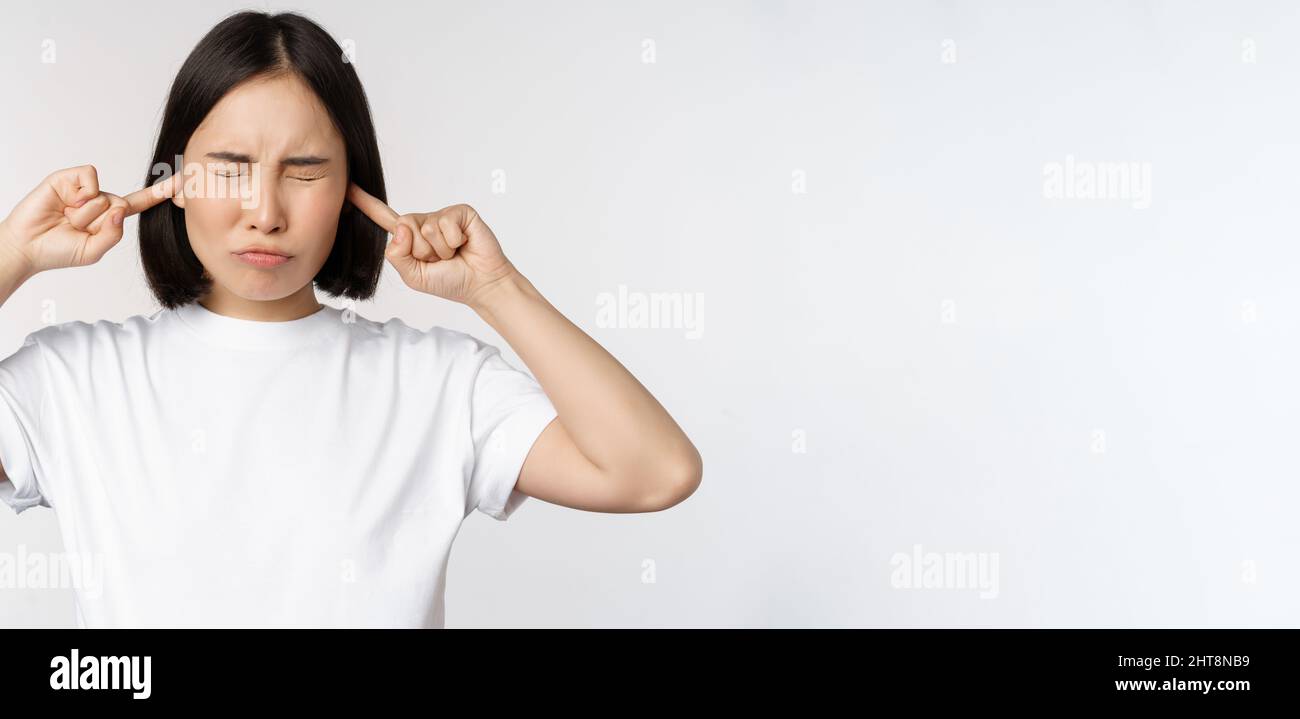 Portrait of asian woman shut ears and feeling discomfort from loud ...