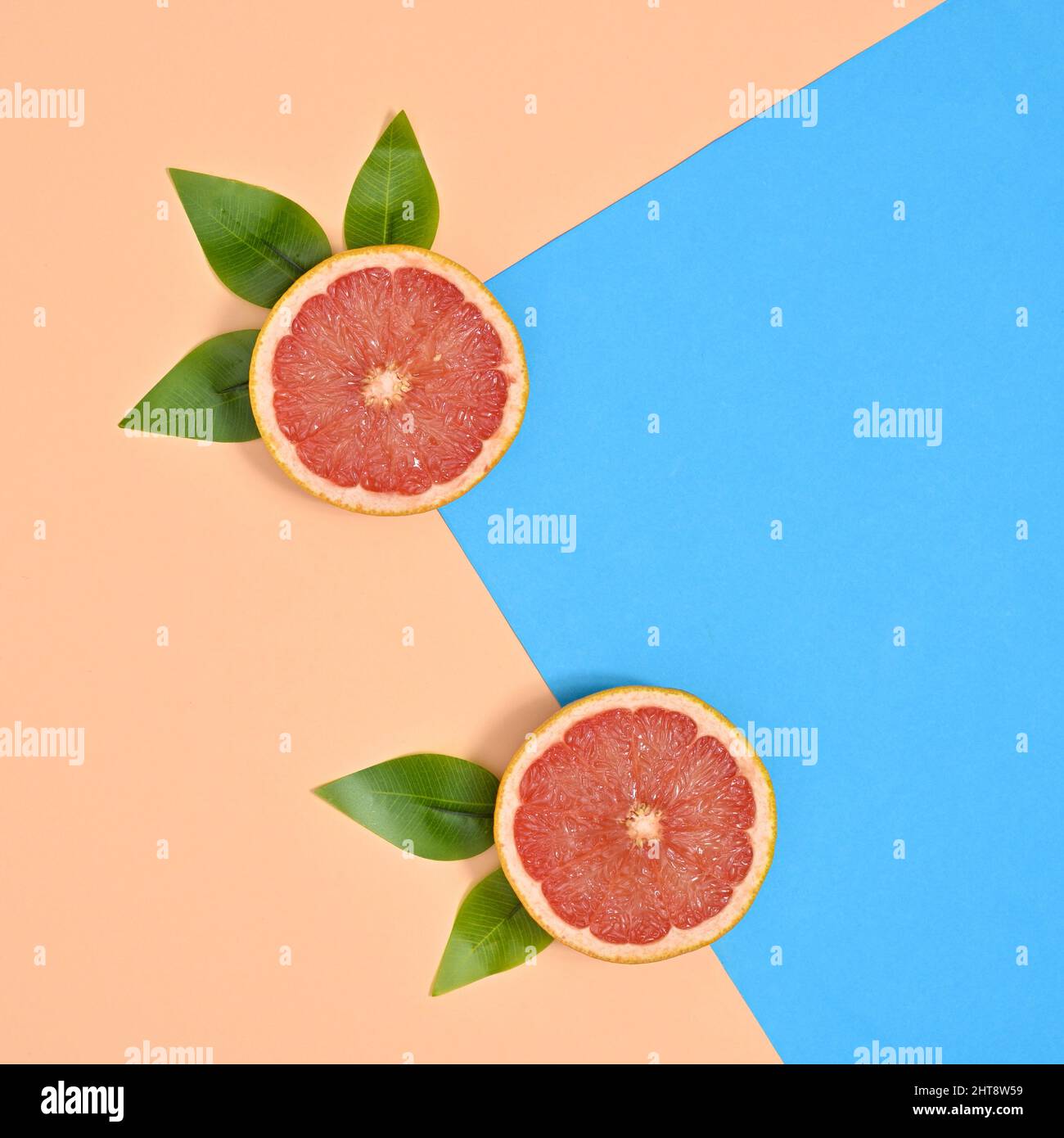 Fresh citrus fruits composition of sliced grapefruits on pastel beige and blue background. Flat ...