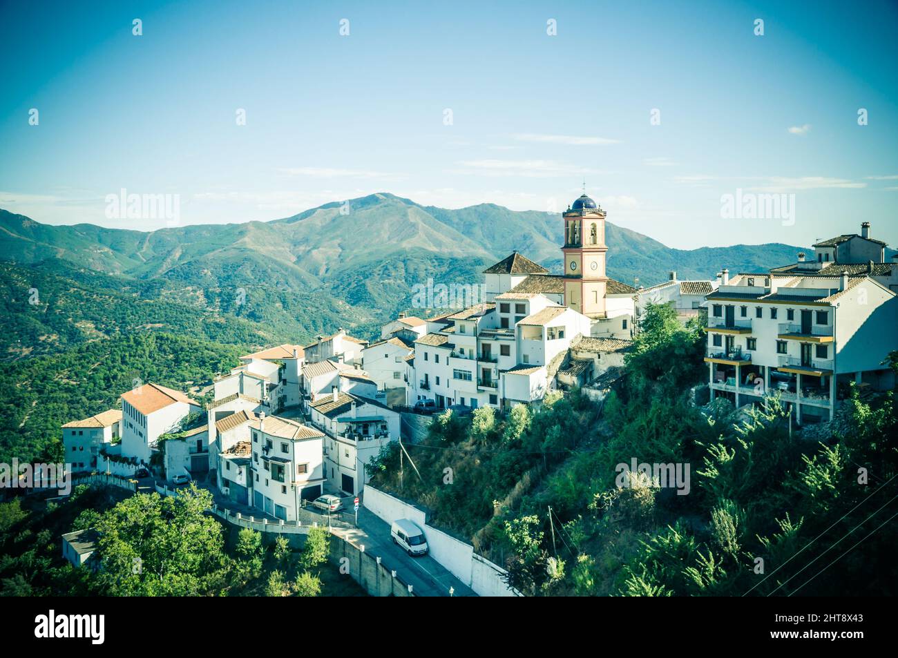 Mesmerizing view a cityscape of Benadalid surrounded by green mountains ...