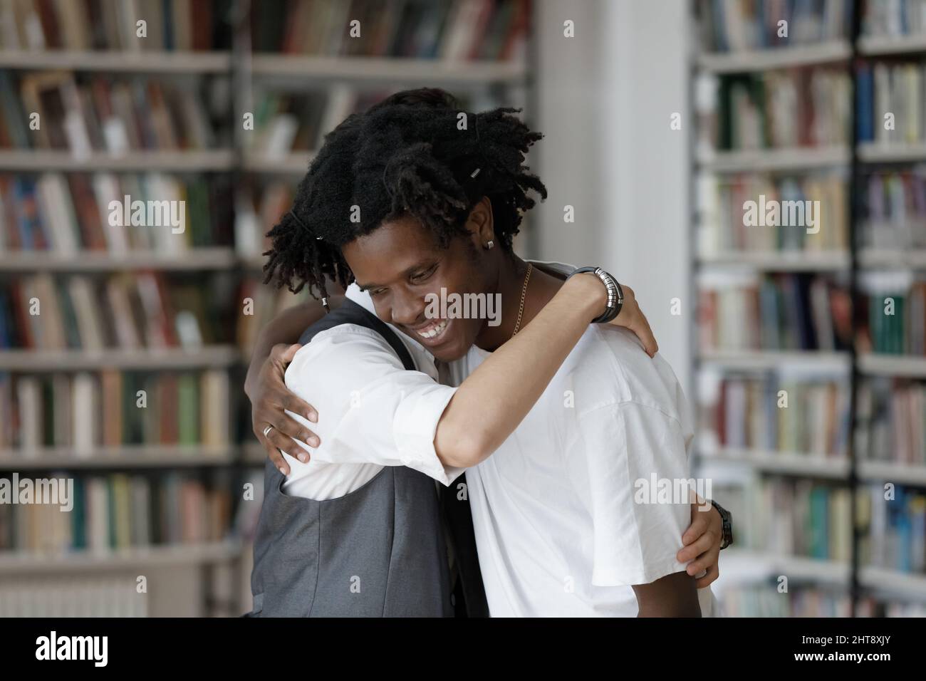 Happy young guy cuddling smiling African American friend Stock Photo ...