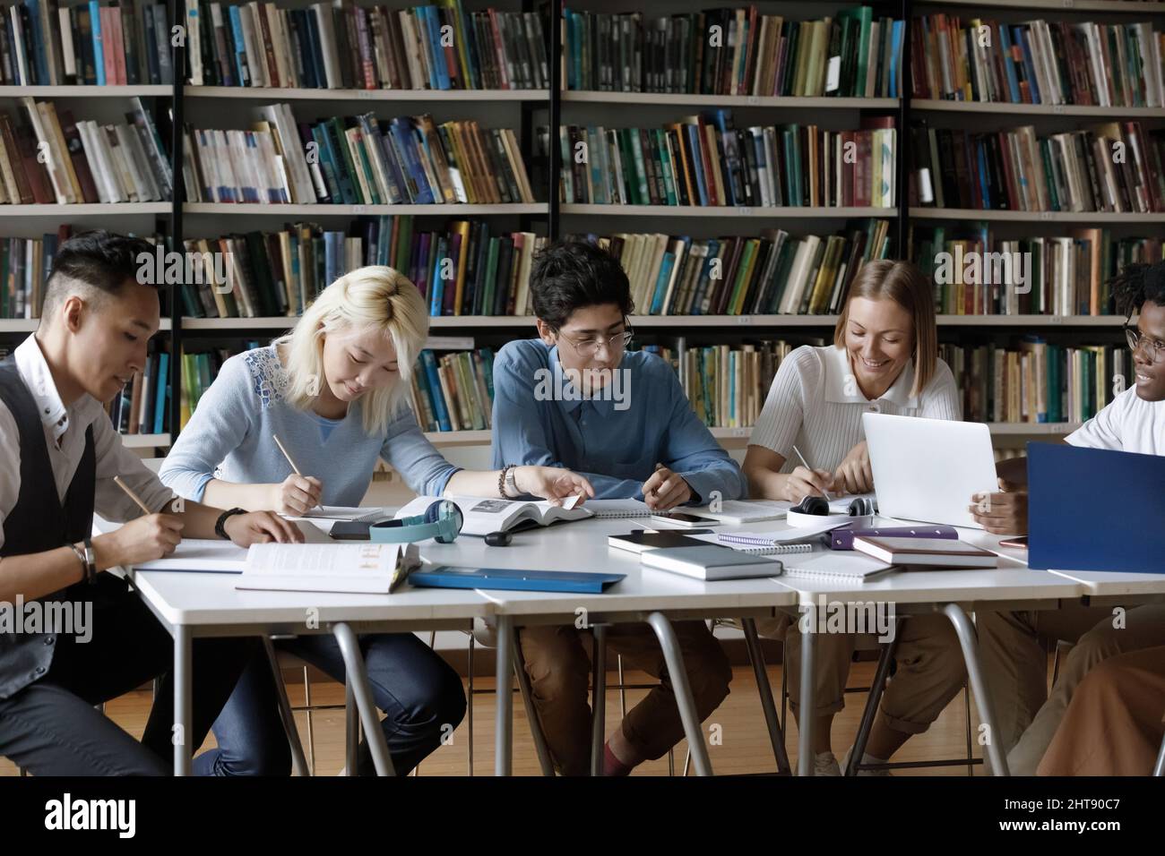 Focused group of happy diverse students studying in library Stock Photo ...