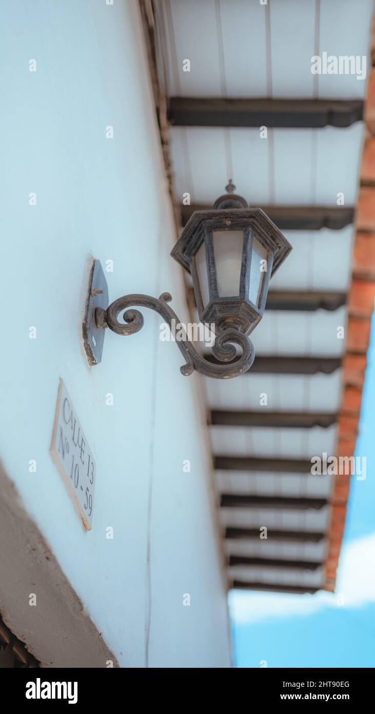 Metal bulbs attached to the white wall of the house with cover on the ...