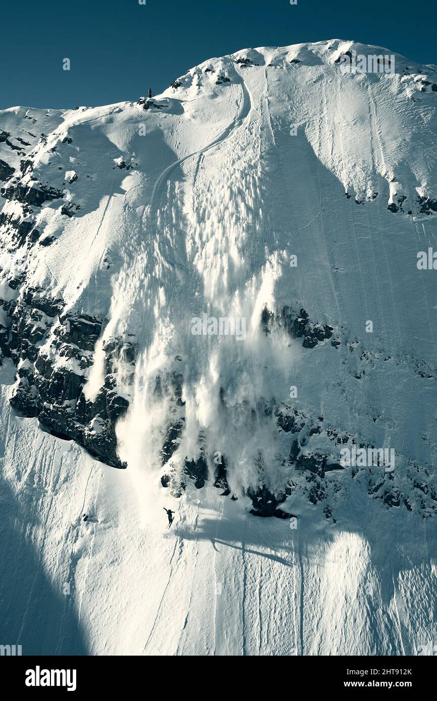 Vertical shot of ski way in high snow-capped mountains with gray sky on ...