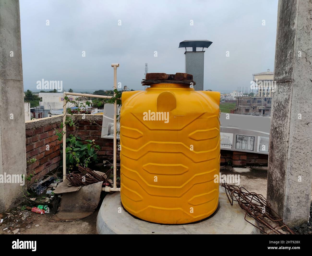 Yellow plastic water tank on the rooftop of the residential building at ...