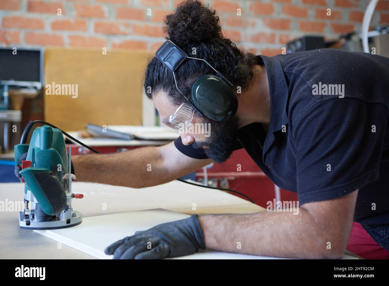 Hispanic male polishing wood with electric hand sander Stock Photo - Alamy
