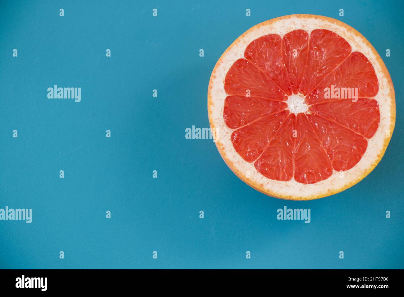 Closeup of a sliced grapefruit on the blue background, cut grapefruit ...
