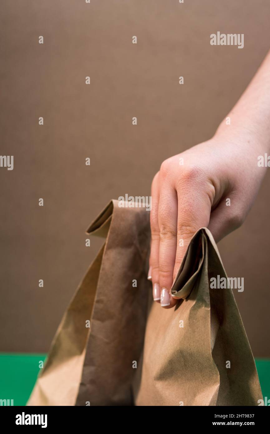 Hand holding brown paper bag hi-res stock photography and images - Alamy