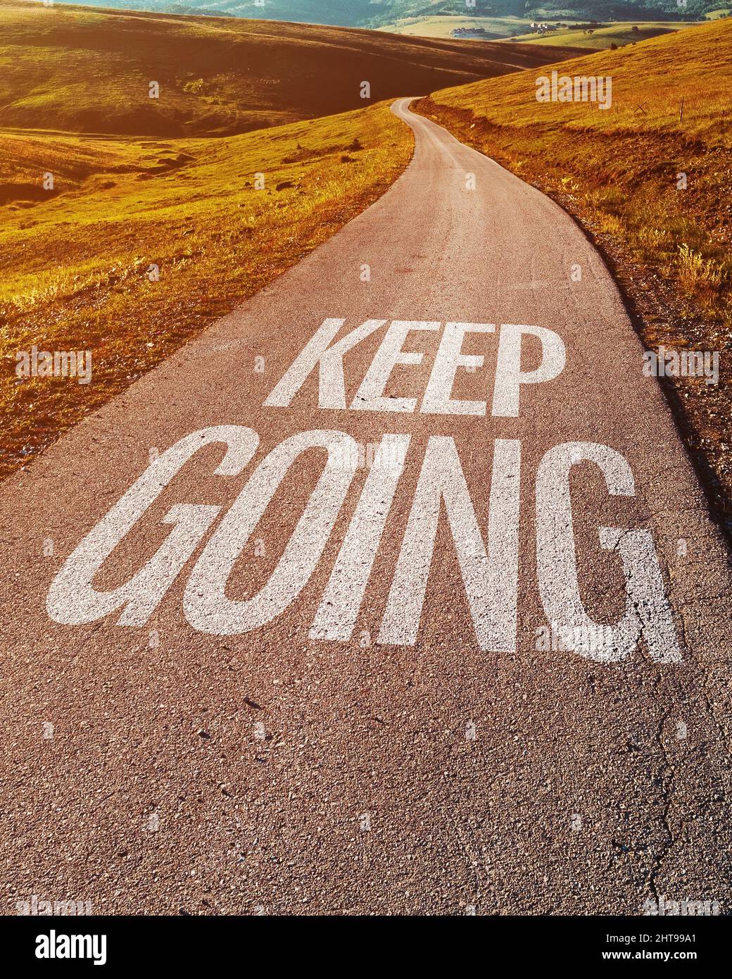 Keep going motivational message on asphalt road through countryside ...