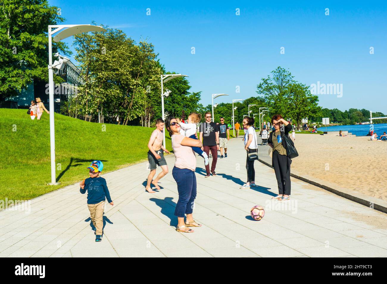 View of people walking on a footpath by a beach next to the Odra river ...
