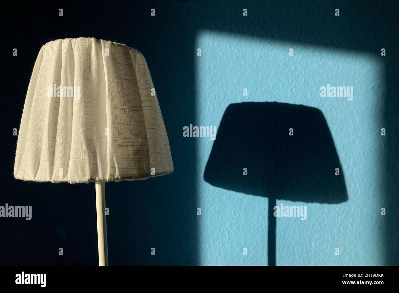 Lamp with a shadow on the blue wall Stock Photo - Alamy