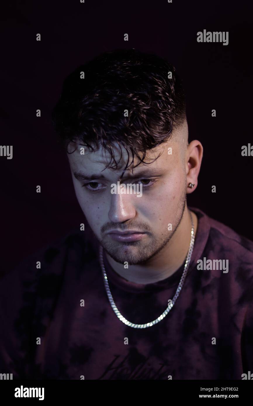 Vertical portrait of an upset caucasian man against a black background ...