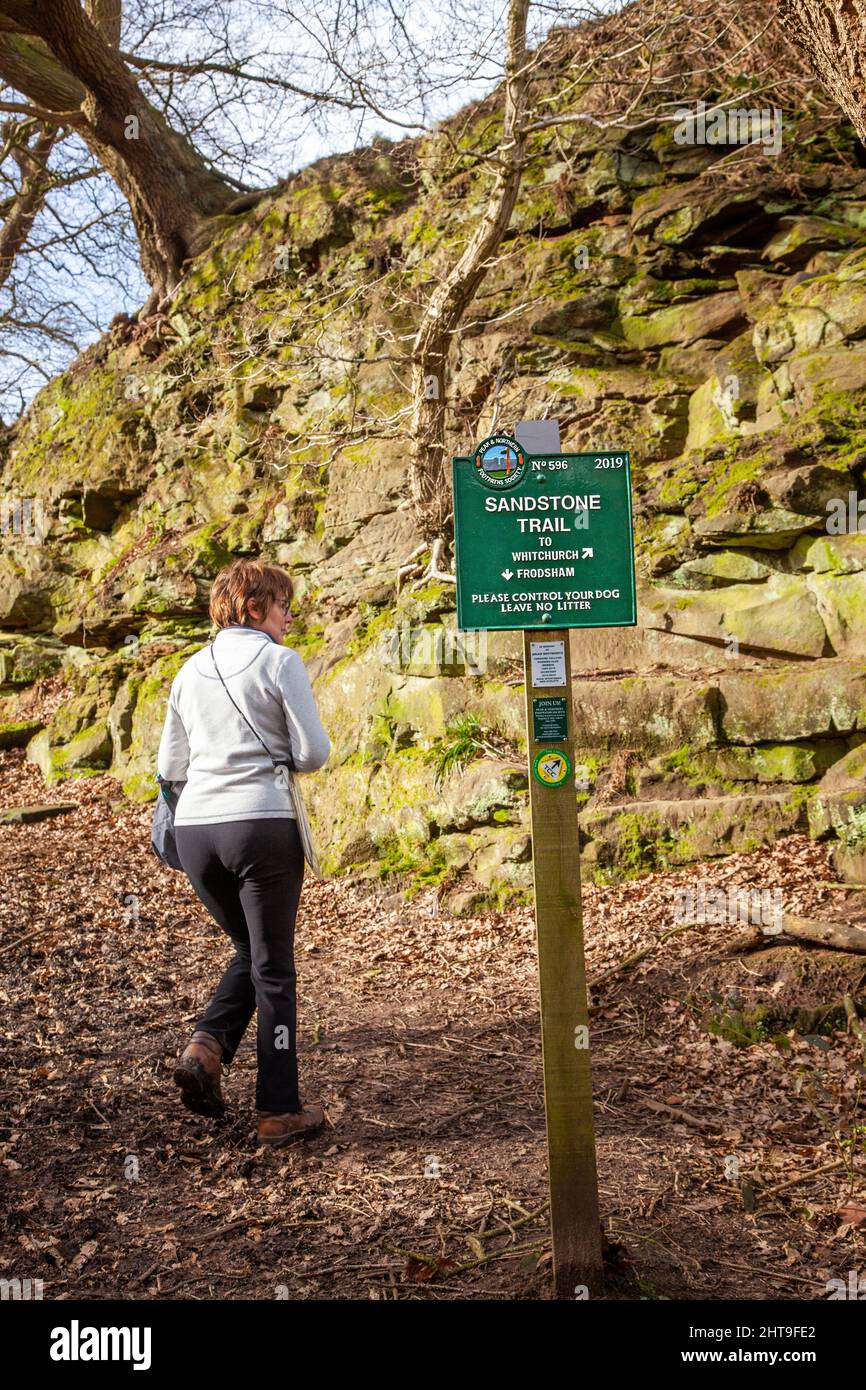 Woman walking past a waymarker sign post on the Sandstone trail long ...