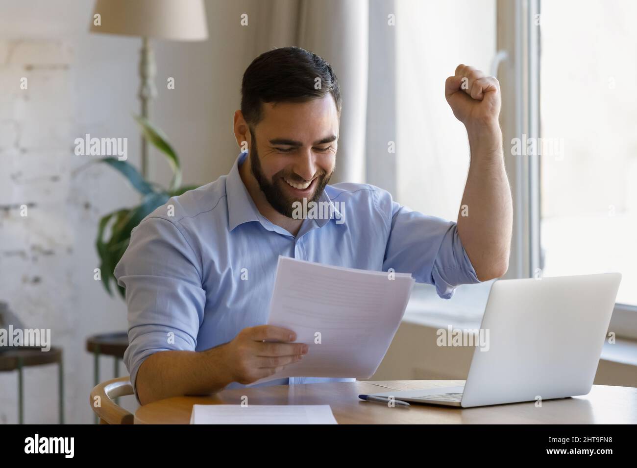 Man holding papers read information looks overjoyed, celebrate success ...