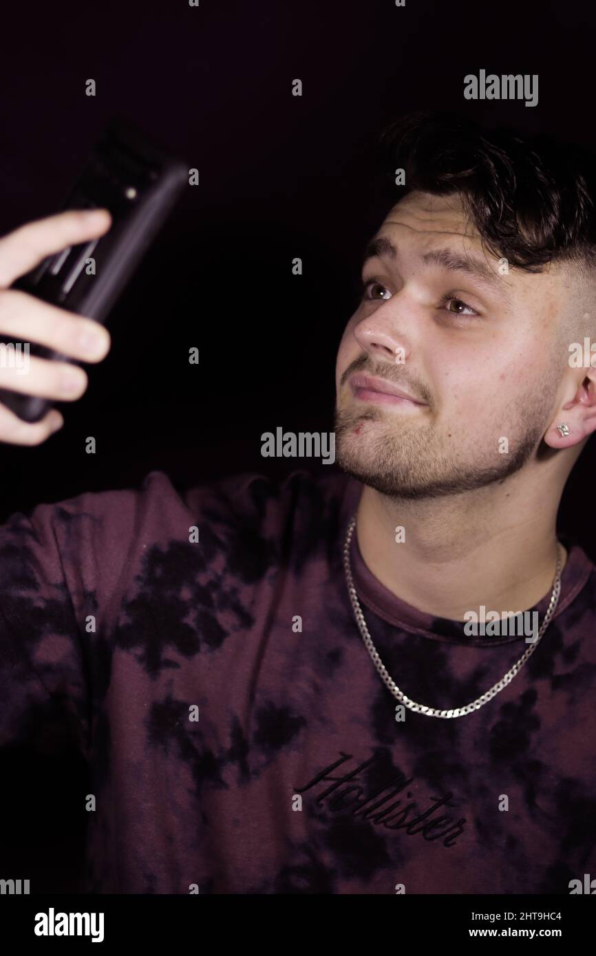 Vertical shot of a young caucasian man taking a selfie on his ...