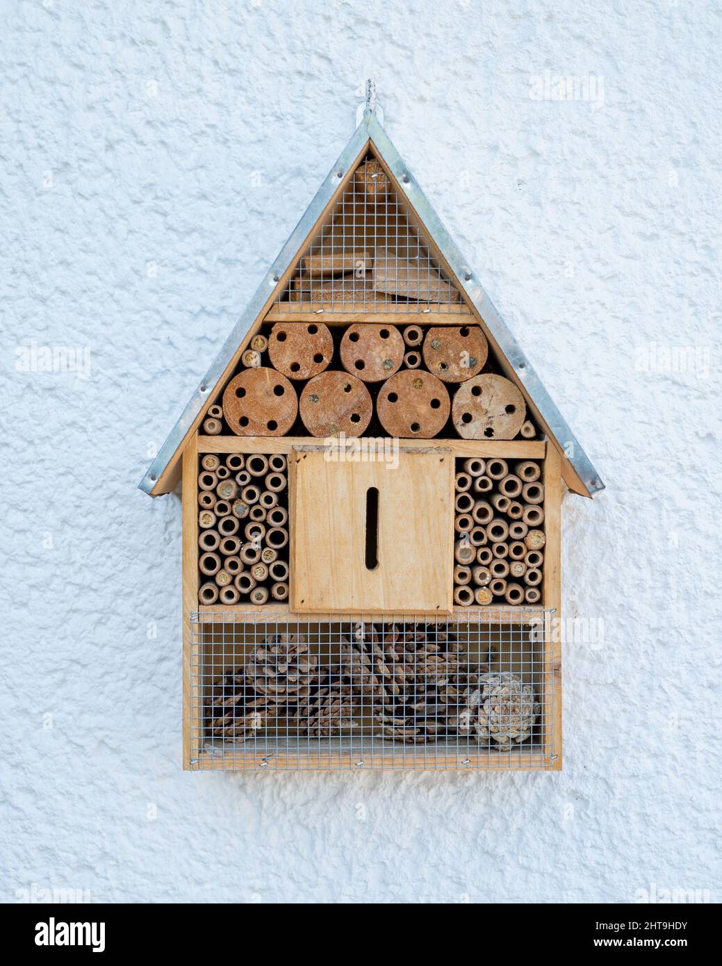 Wooden insect house hanged on a white wall Stock Photo - Alamy
