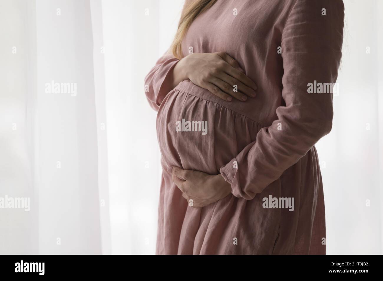 Expecting mom wearing natural dress for pregnant, holding big tummy ...