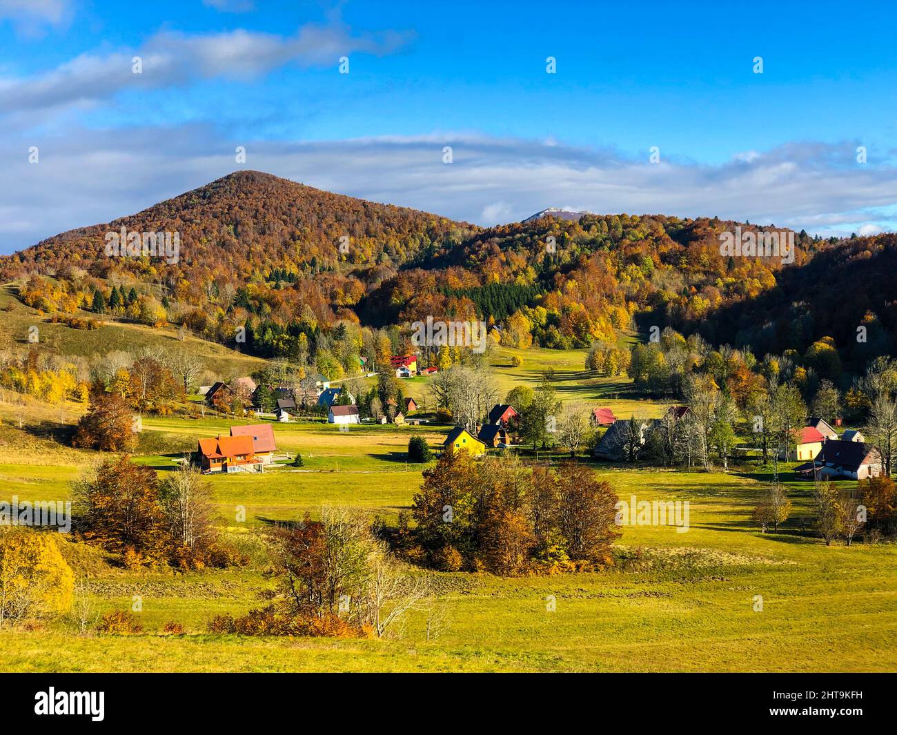 Photo of a rural landscape with forest hills, grasslands and houses ...