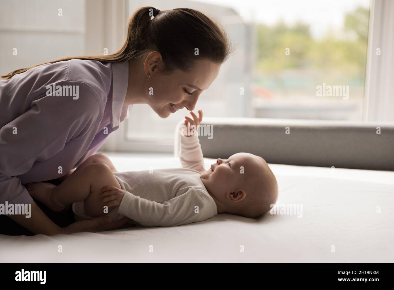 Happy new mother caressing, cuddling sweet baby Stock Photo - Alamy