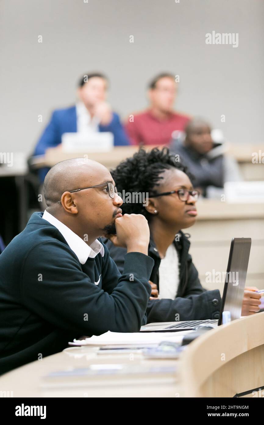 Closeup of Diverse adult delegates attending a business lecture in a ...
