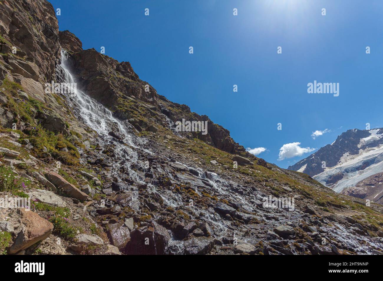 Small waterfall with glacier background Stock Photo - Alamy