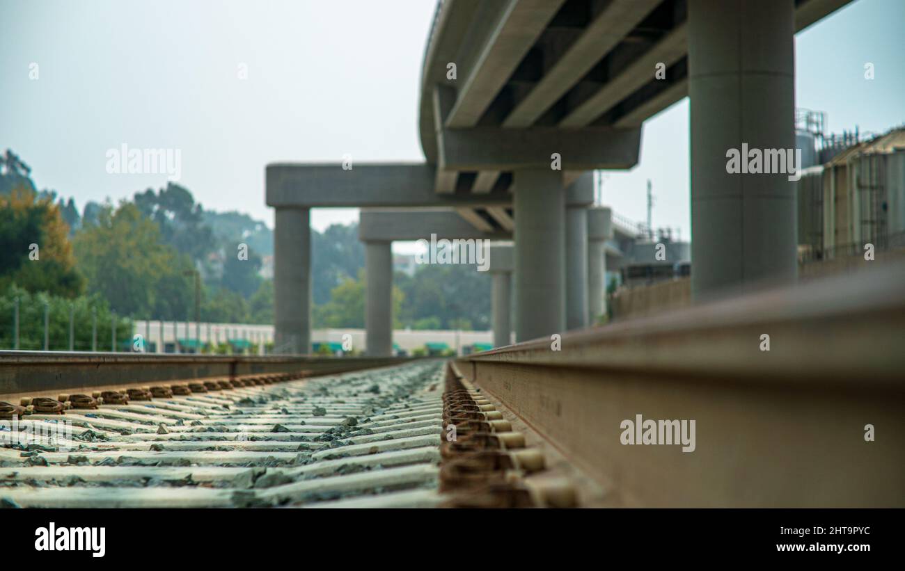 Train tracks under a bridge Stock Photo - Alamy