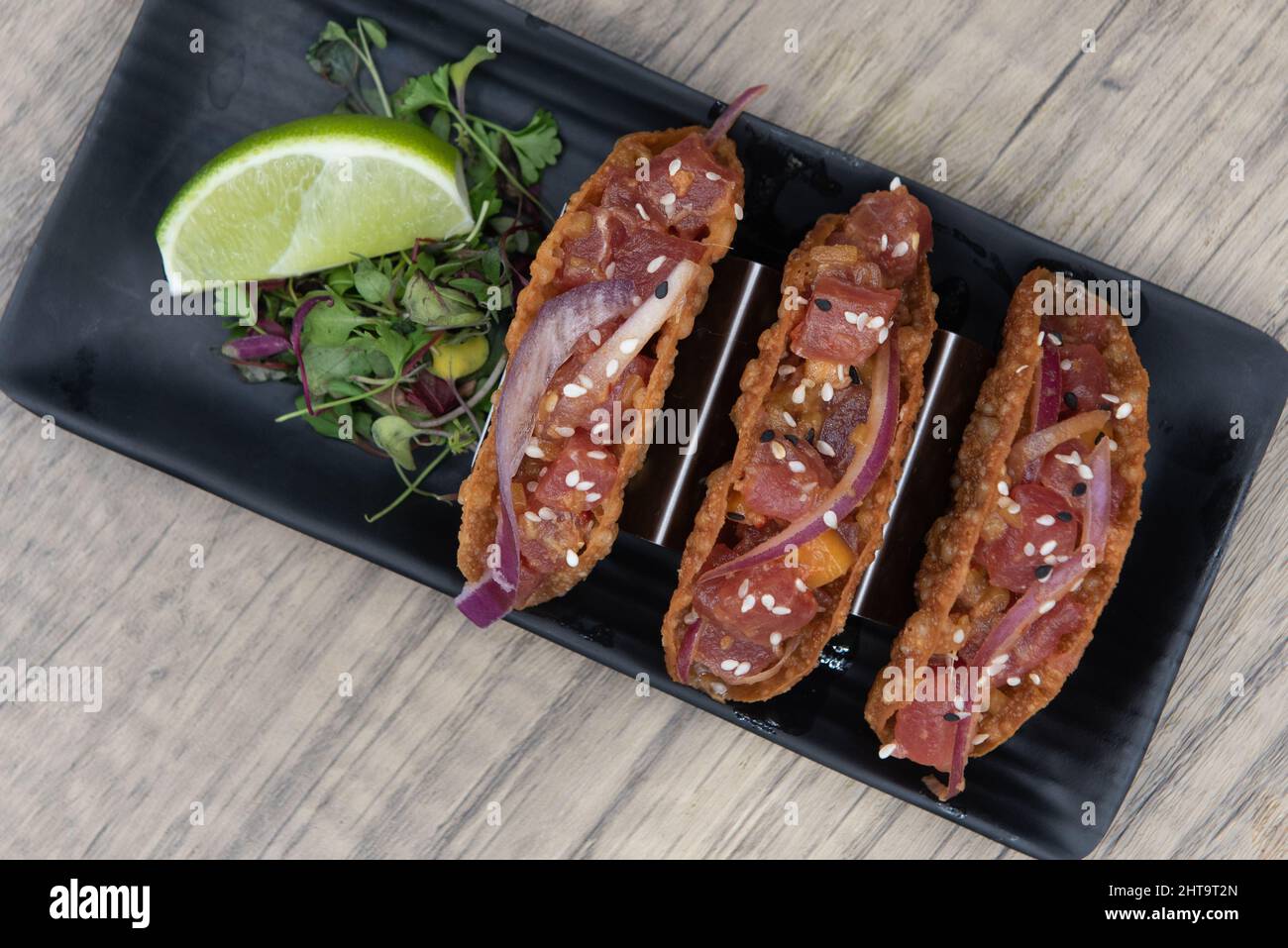 Overhead view of tasty appetizer of ahi poke tacos in a crispy shell to ...