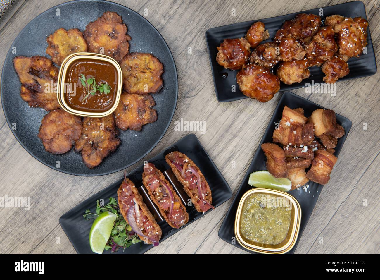 Hearty family style feast with fried plantains, ahi poke tacos, crispy ...