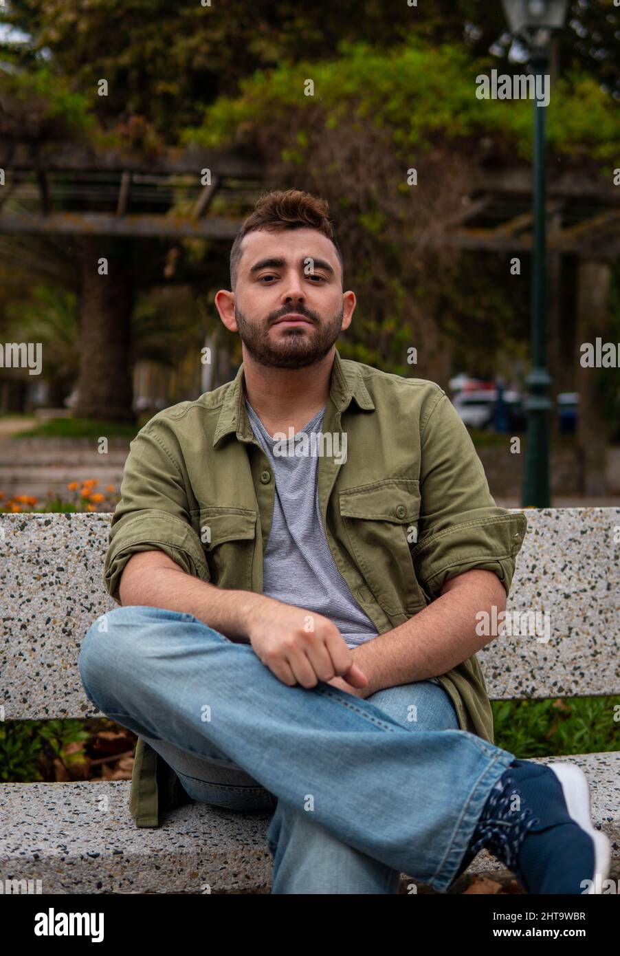 A Caucasian 24 years old male on the beach in Spain sitting on a park ...
