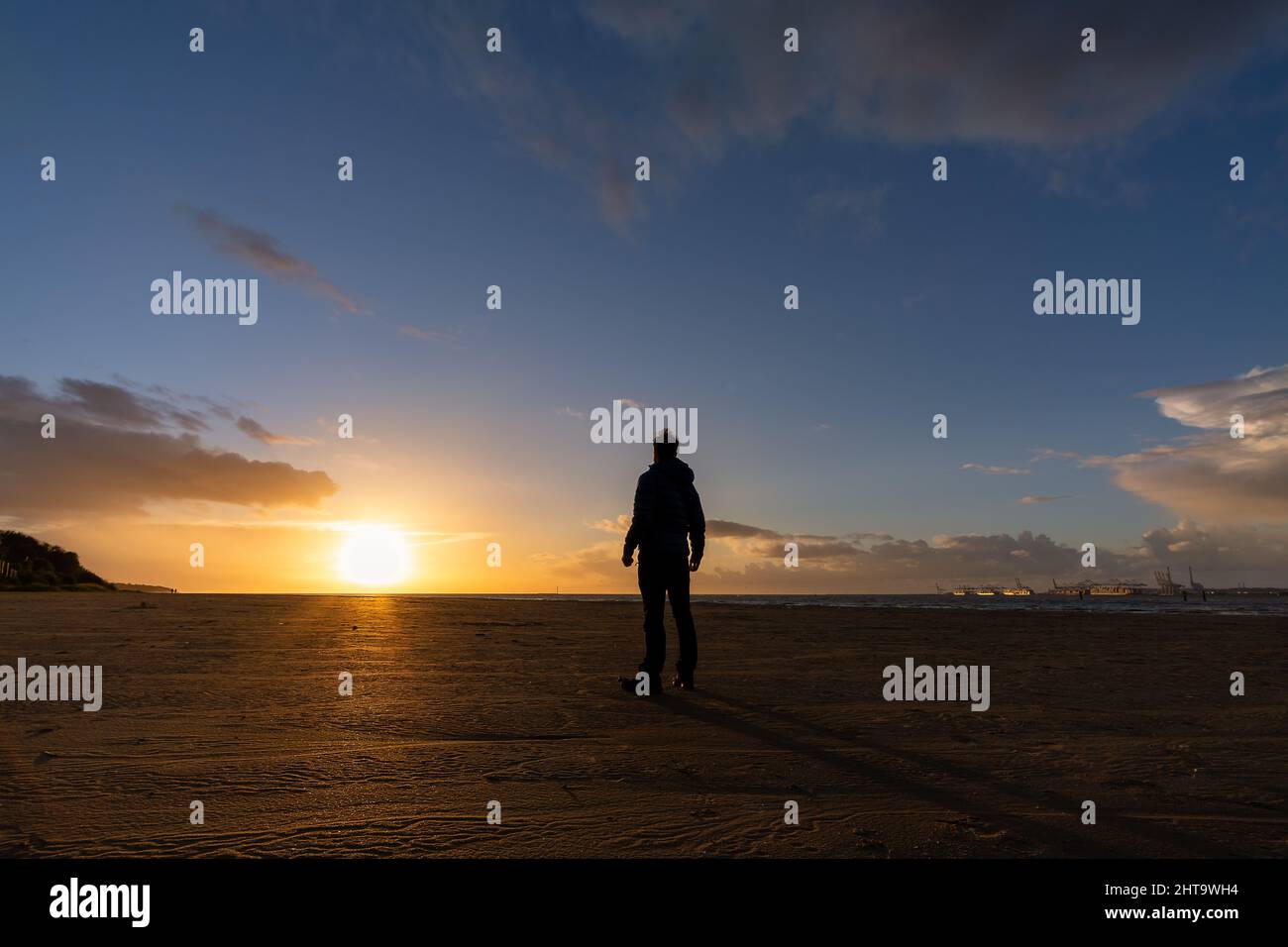 Closeup of a Young man standing watching sunset on beach Stock Photo ...